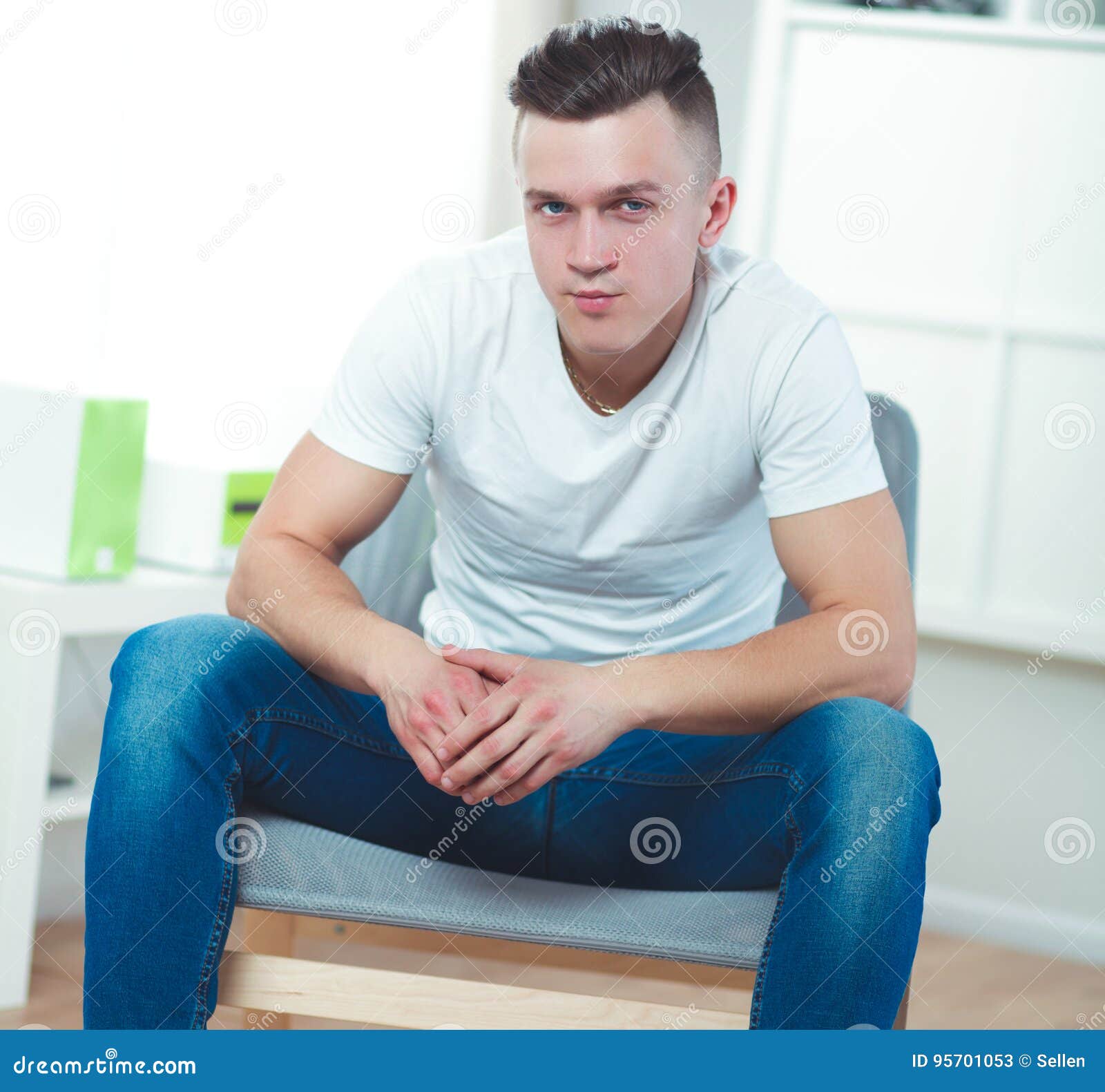 Young man sitting on chair stock image. Image of space - 95701053