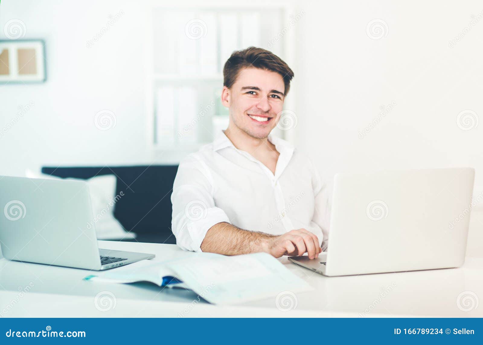 Young Man Sitting in Chair and Working on Laptop Computer Stock Photo ...