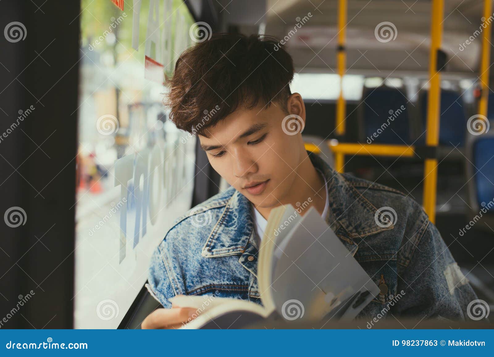Young Man Sitting in City Bus and Reading a Book. Stock Image - Image ...