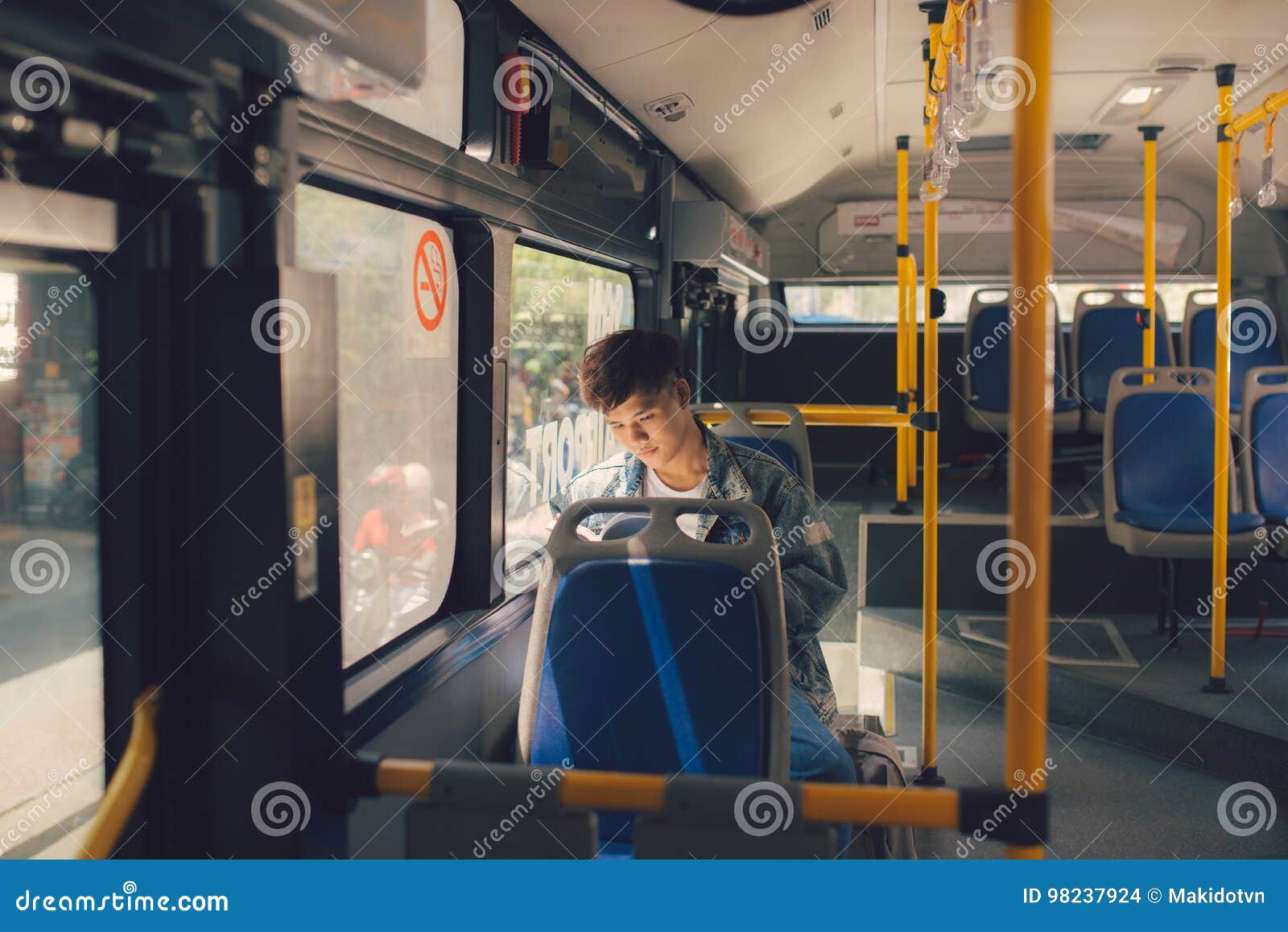 Young Man Sitting in City Bus and Reading a Book. Stock Photo - Image ...