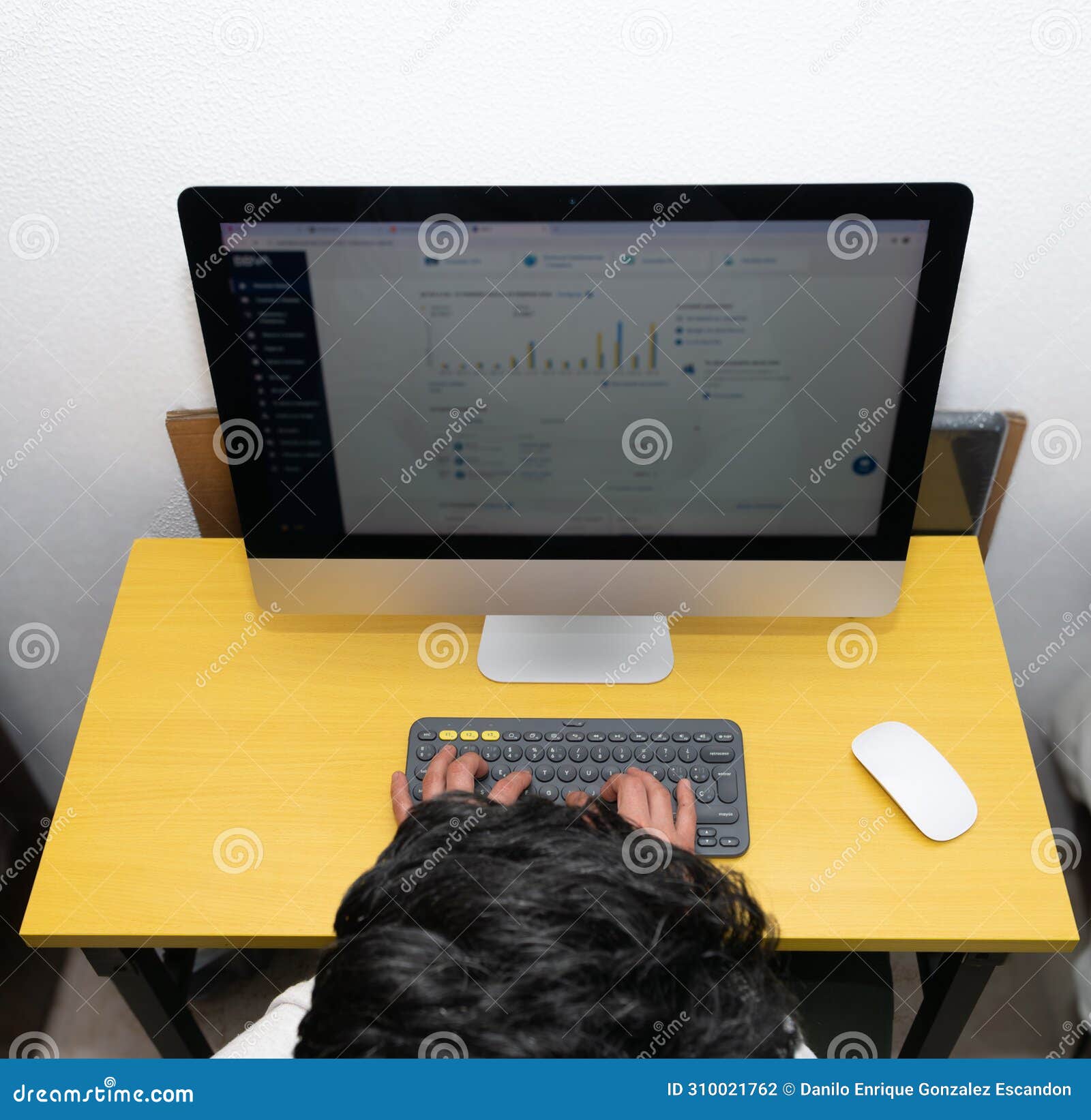 Young Man Sitting in Front of a Computer Reviewing Bank Statistics ...