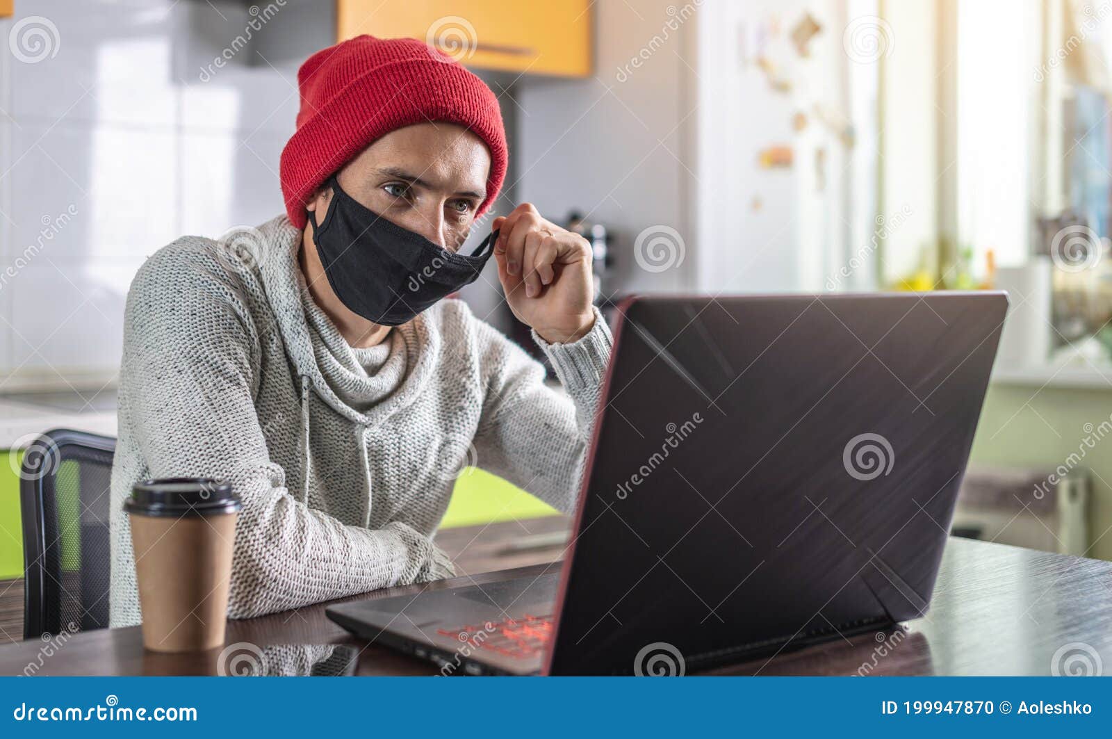 A Young Man is Sitting in Front of a Laptop Screen at Home, Working ...
