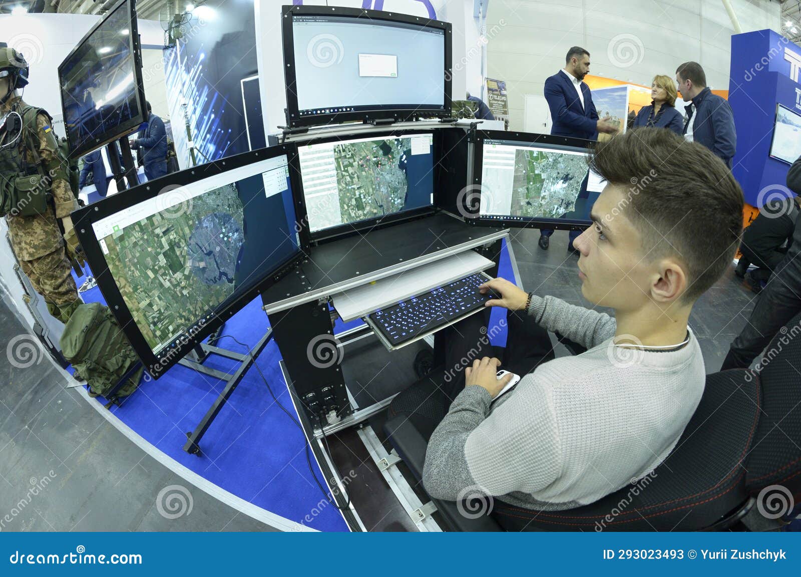 Young Man Sitting in Front of Monitors and Working with Military Computer-assisted Dispatch ...