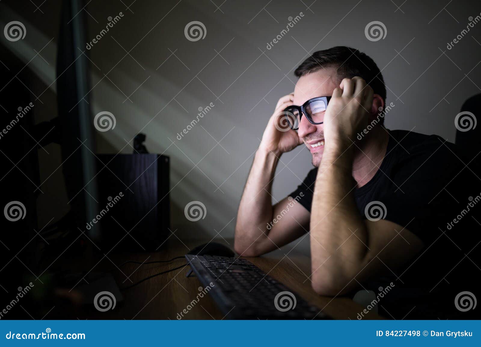 Young Man Sitting with Hands on Head in Front of Computer Stock Photo ...