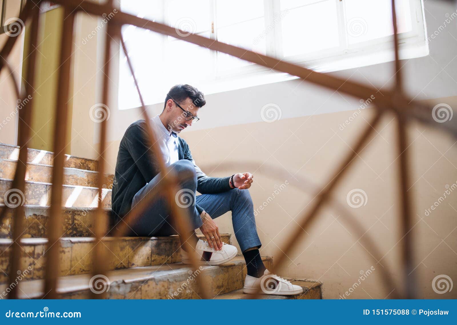 A Young Man Sitting Indoors on Staircase. Stock Photo - Image of ...