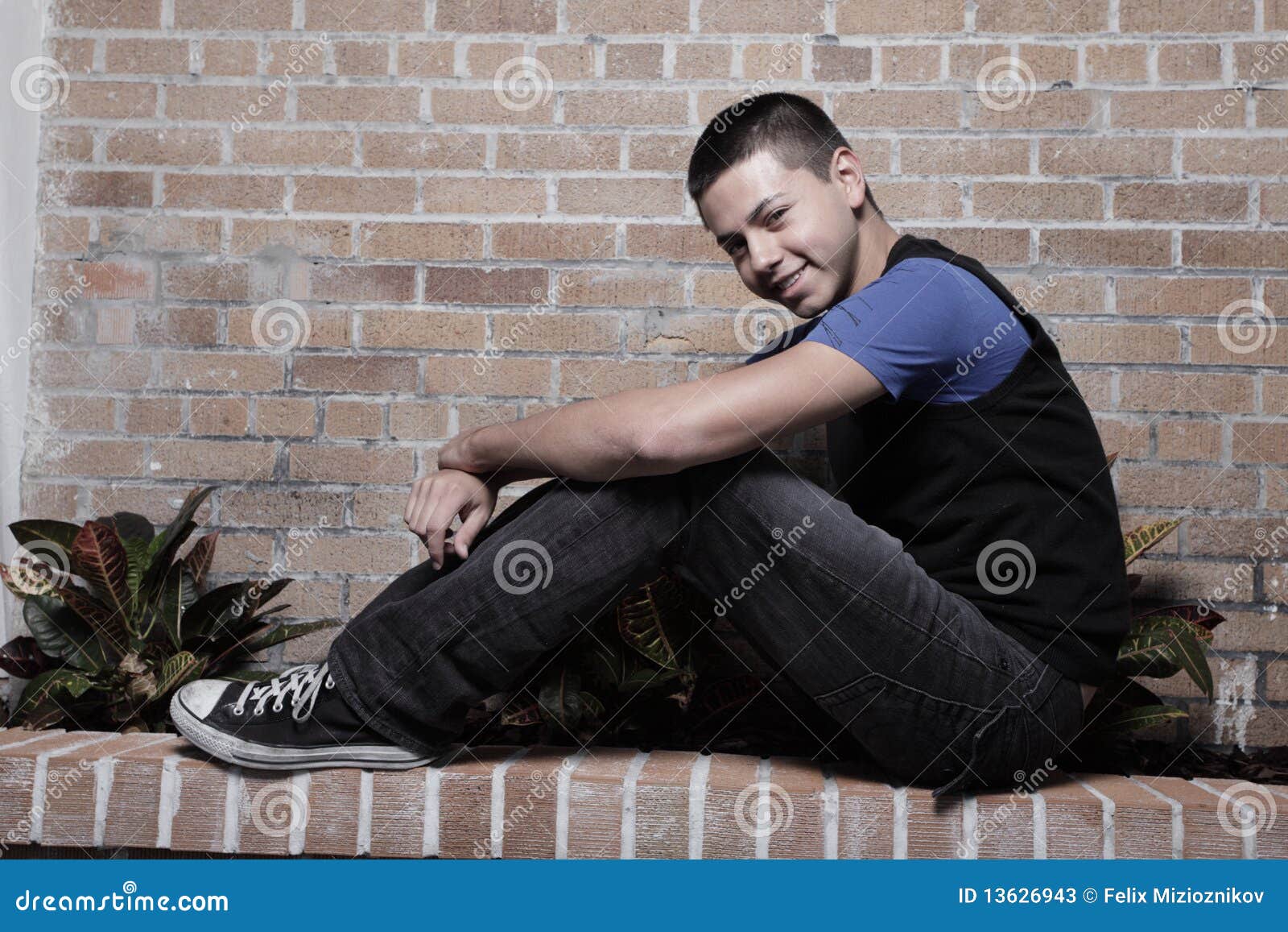 Young Man Sitting on a Ledge Stock Image - Image of smiling, mature ...