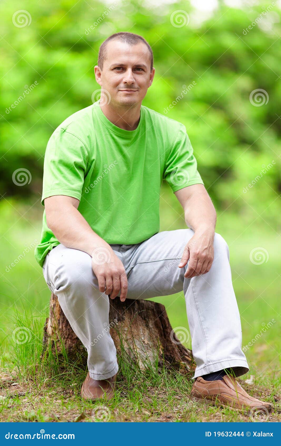 Young man sitting on a log stock photo. Image of alone - 19632444