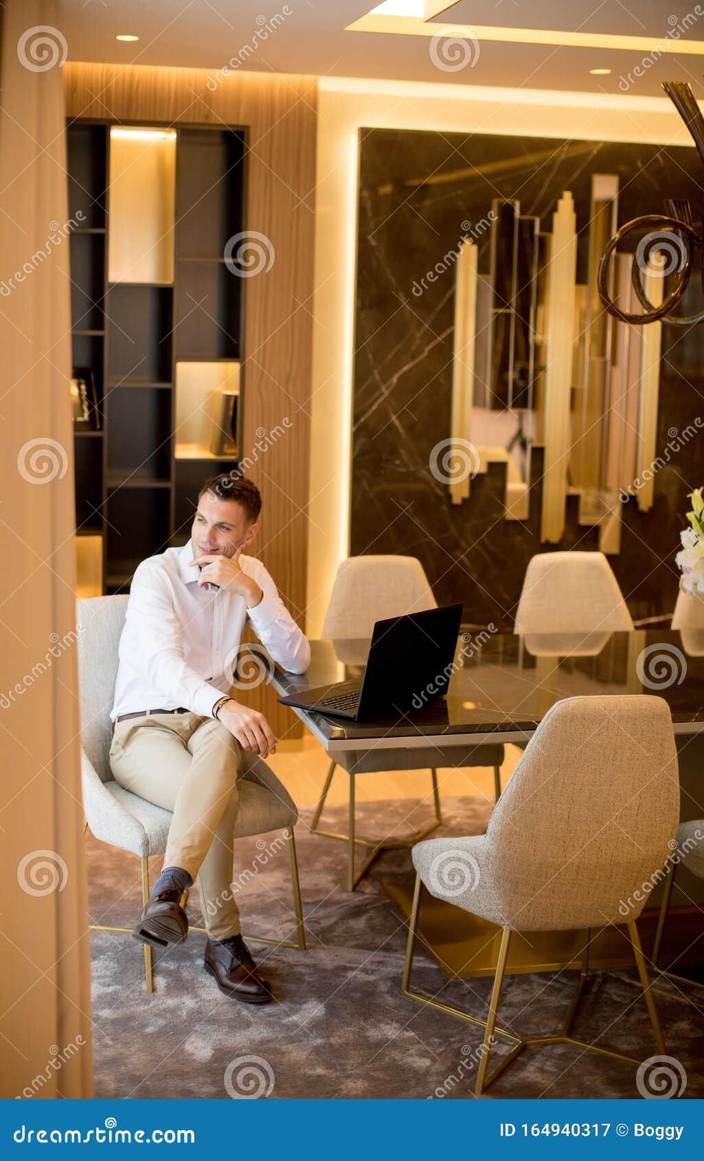 Young Man Sitting in a Luxurious Room in Front of a Laptop Computer ...