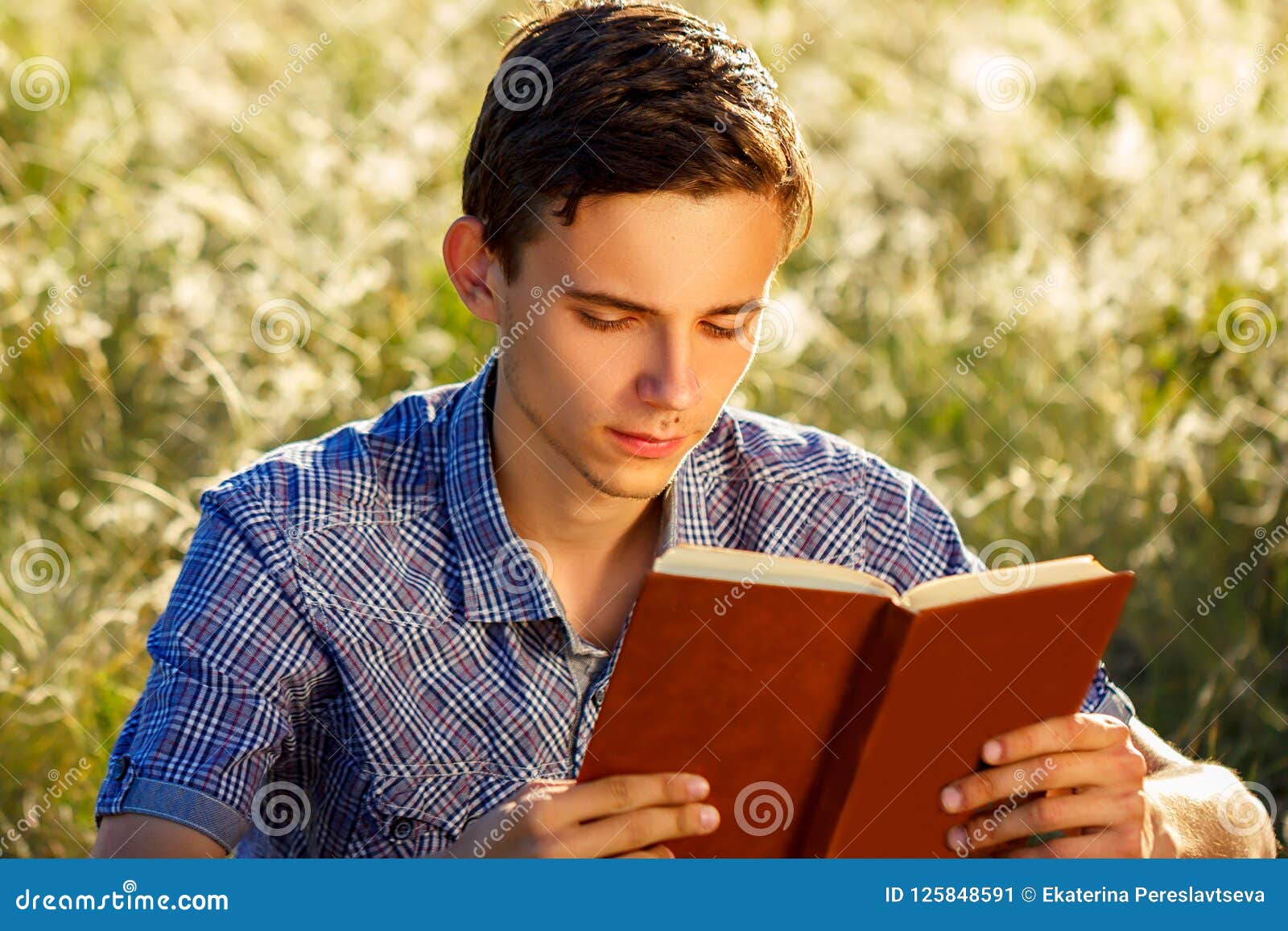 Young Man Sitting in Nature Reading a Book Stock Image - Image of ...