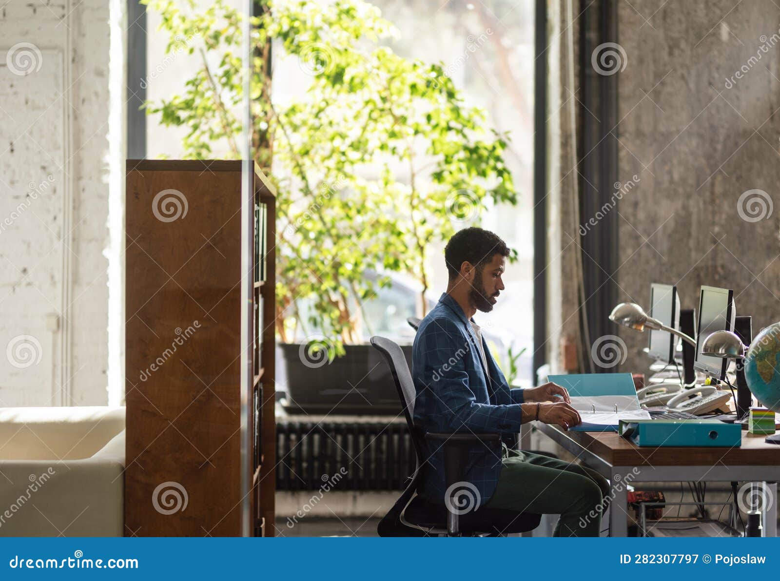Young Man Sitting in Office and Working. Stock Image - Image of ...