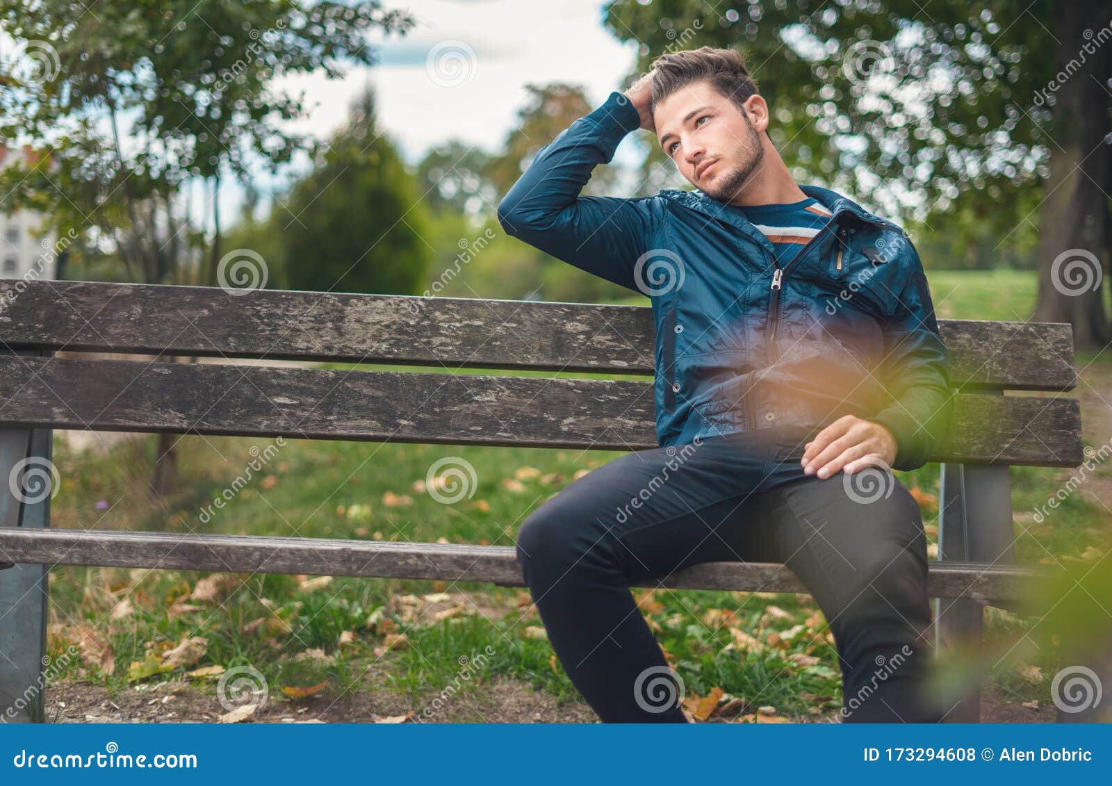 Young Man Sitting in a Park on the Bench. Handsome Guy Relaxing Stock ...