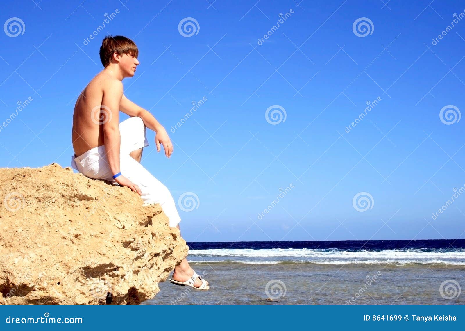 Young Man Sitting on a Rock Stock Image - Image of leisure, lazy: 8641699
