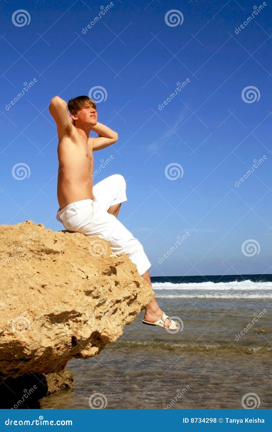 Young Man Sitting on a Rock Stock Photo - Image of leisure ...