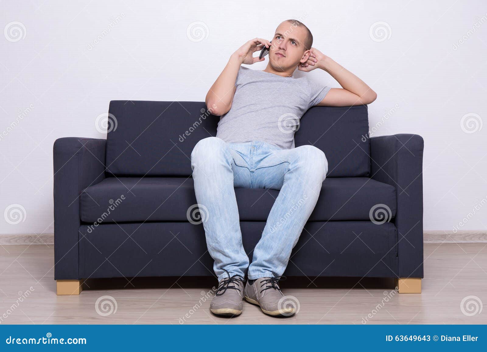Young Man Sitting on Sofa and Talking on Mobile Phone Stock Image ...