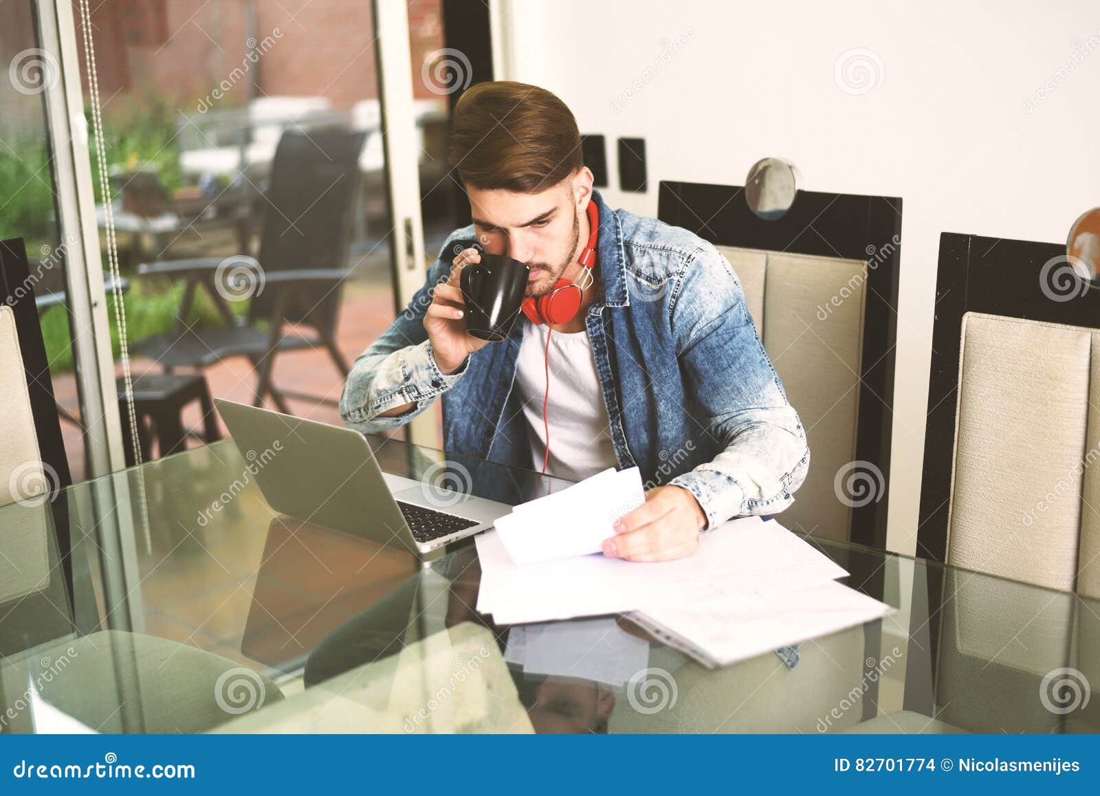 Young Man Sitting at the Table Using His Laptop. Stock Photo - Image of ...