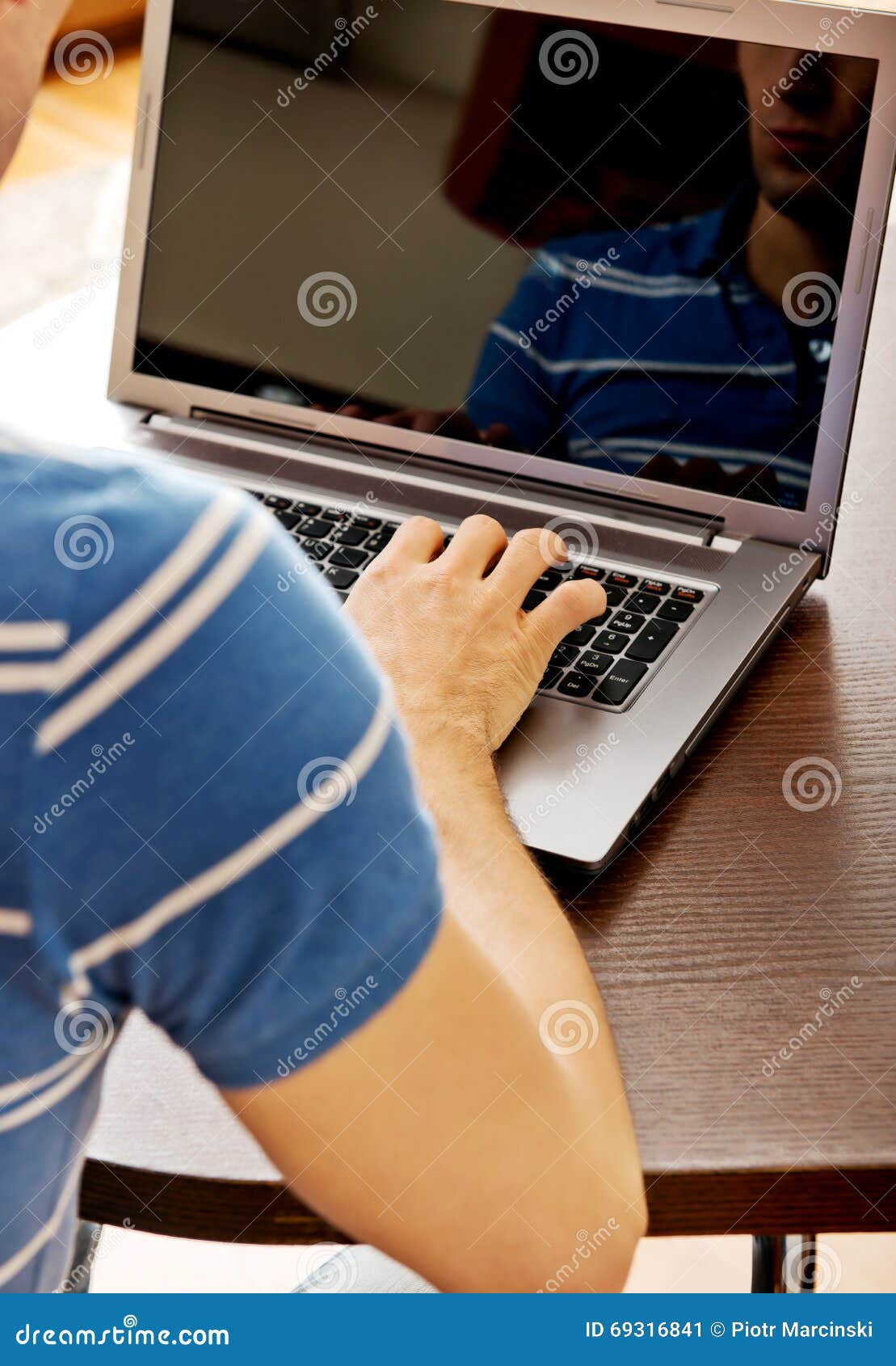 Young Man Sitting at the Table and Using Laptop Stock Image - Image of ...