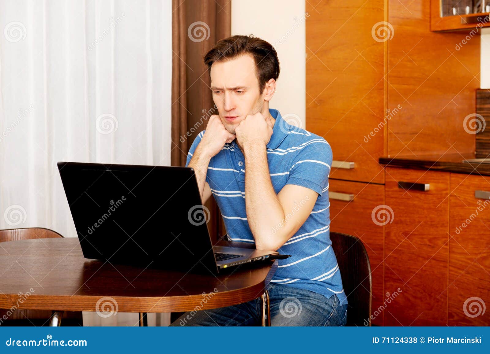 Young Man Sitting at the Table and Using Laptop Stock Photo - Image of ...