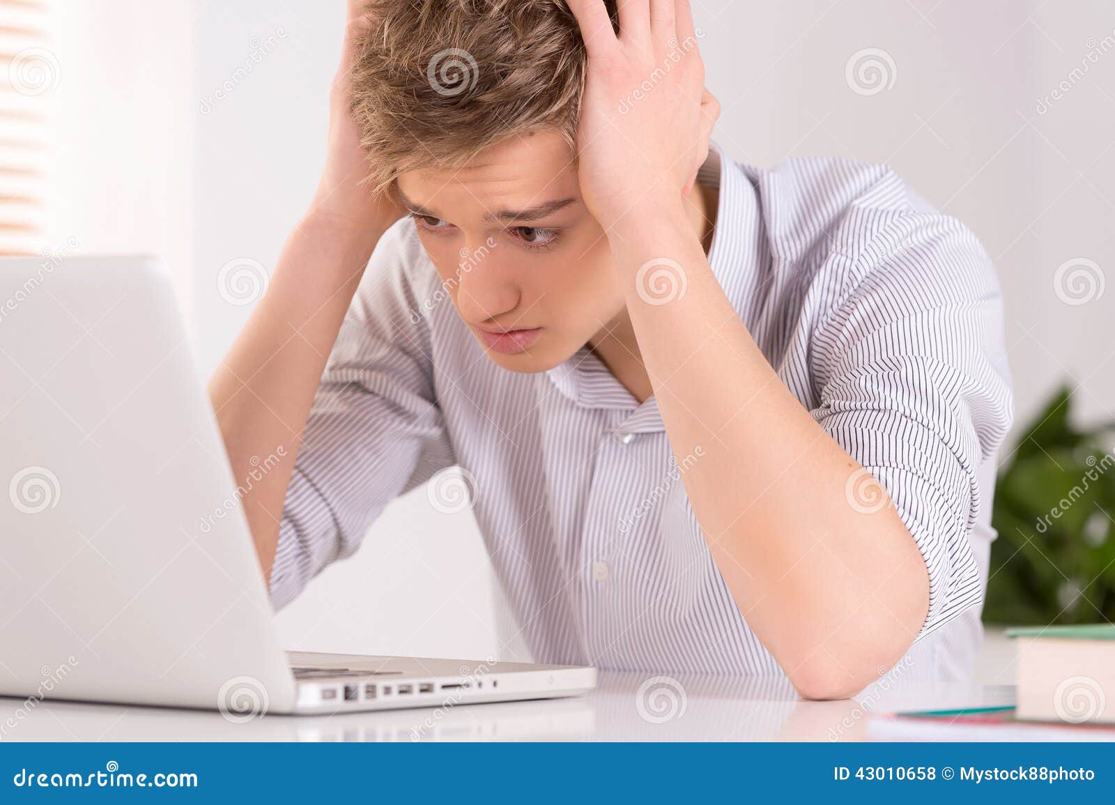 Young Man Sitting at Table and Using Laptop. Stock Photo - Image of ...
