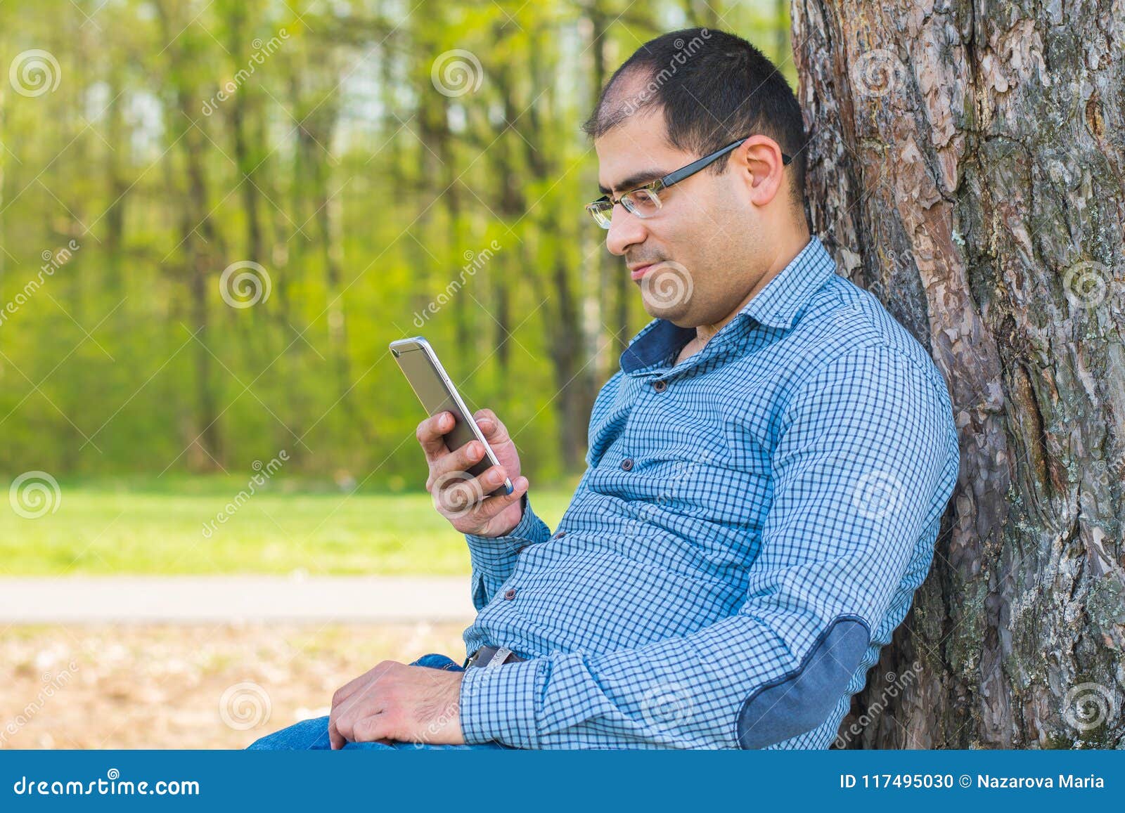 Young Man Sitting Under a Tree Stock Photo - Image of casual, outside ...