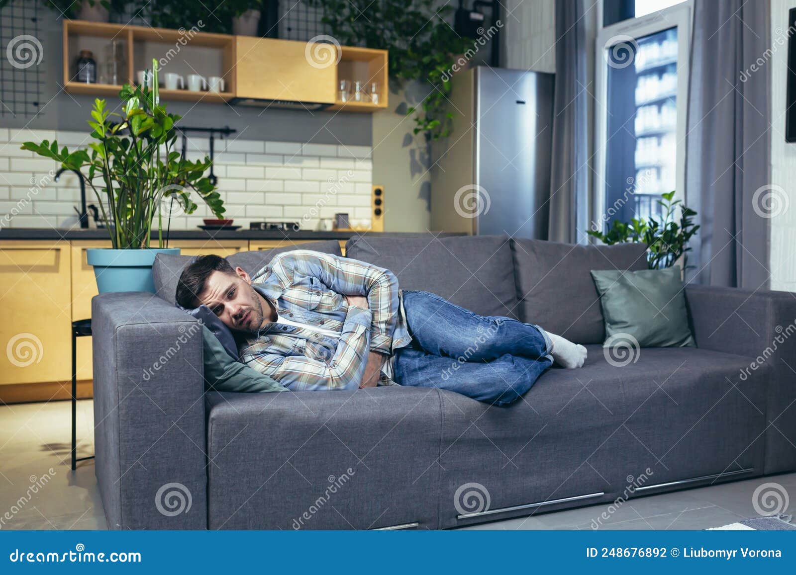 A Young Man is Sleeping and Lying on the Couch at Home. Tired, Feeling ...