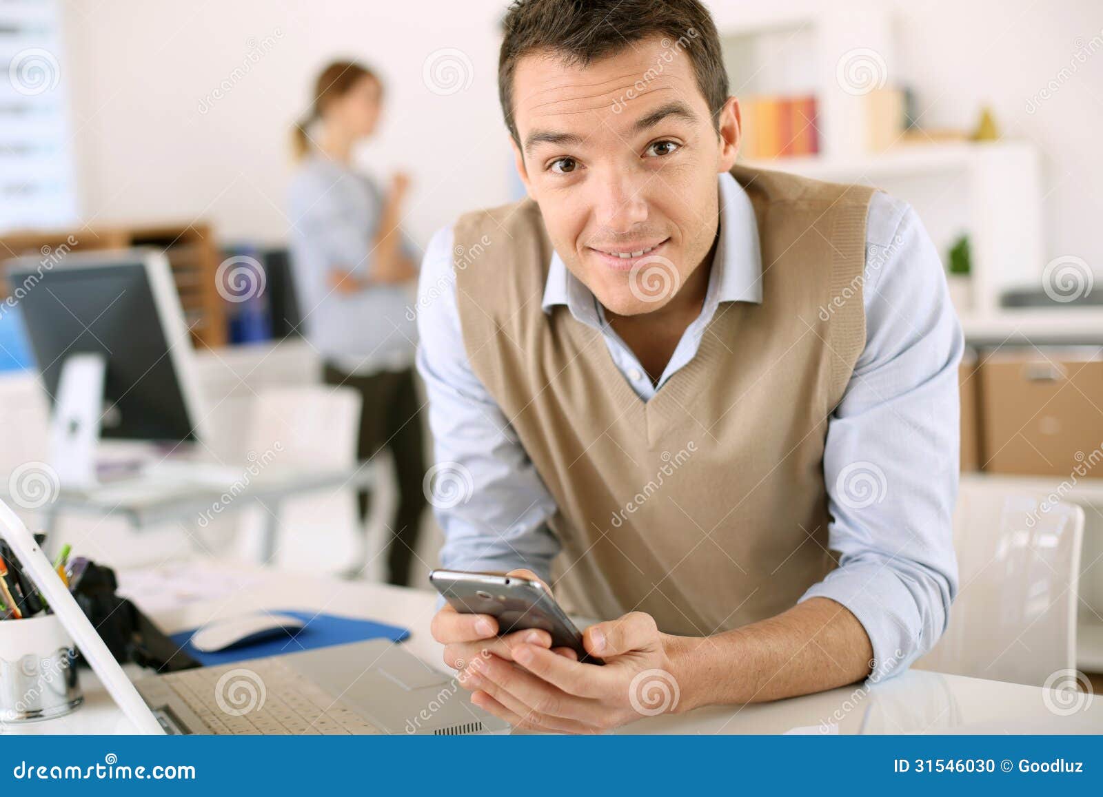 Young Man with Smartphone Sitting in Office Stock Photo - Image of ...