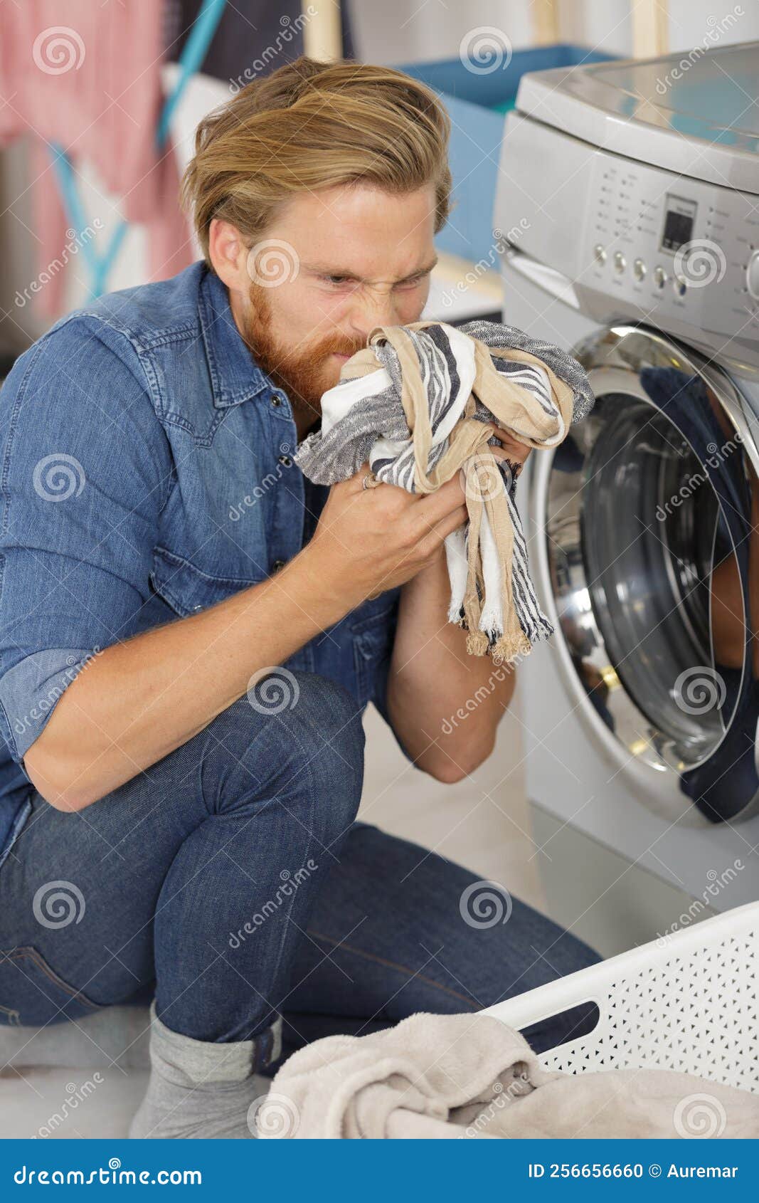 Young Man Smelling Clothes while Doing Laundry Stock Photo - Image of ...