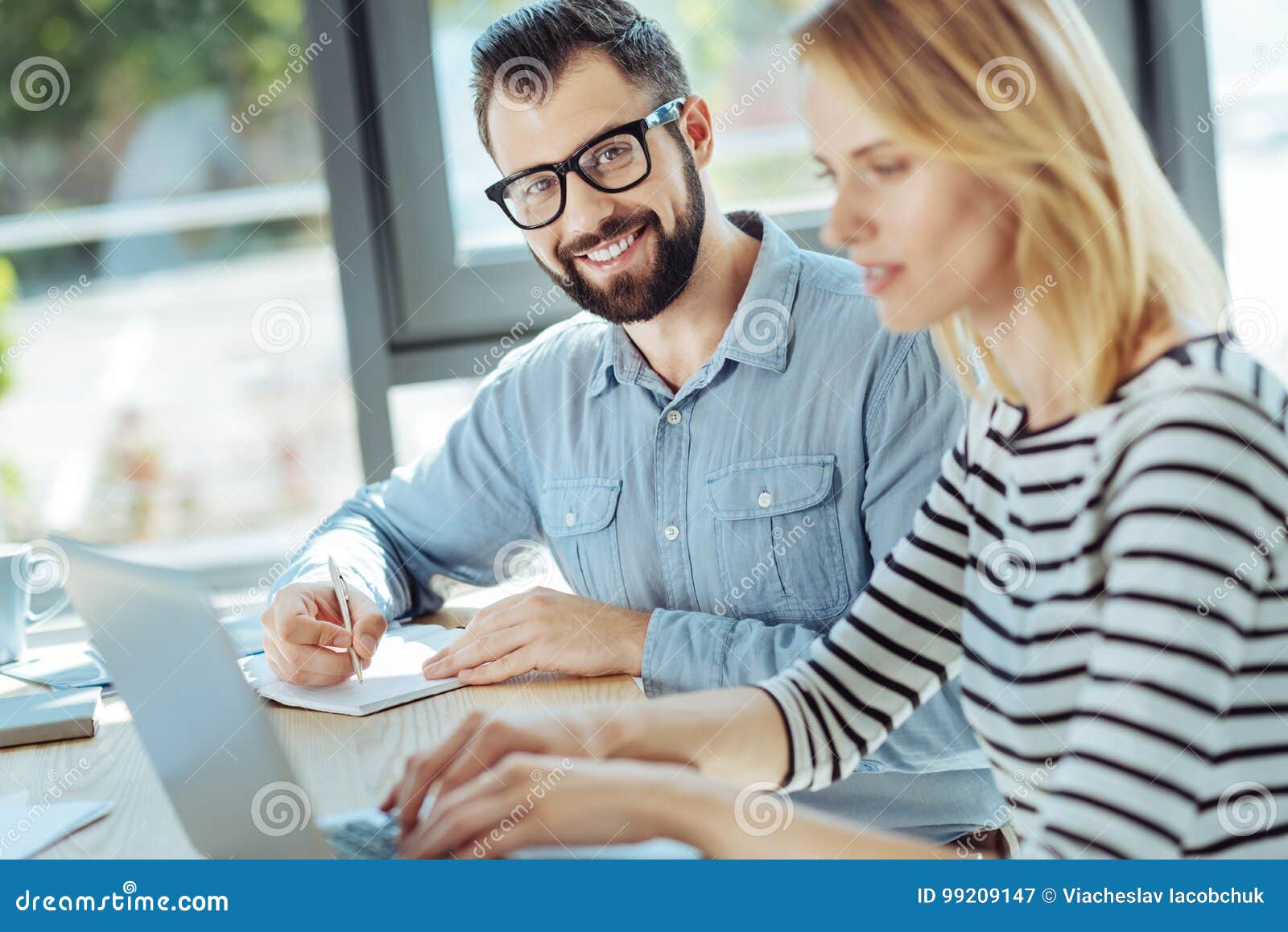 Young Man Smiling at Camera while Writing in Notebook Stock Image ...