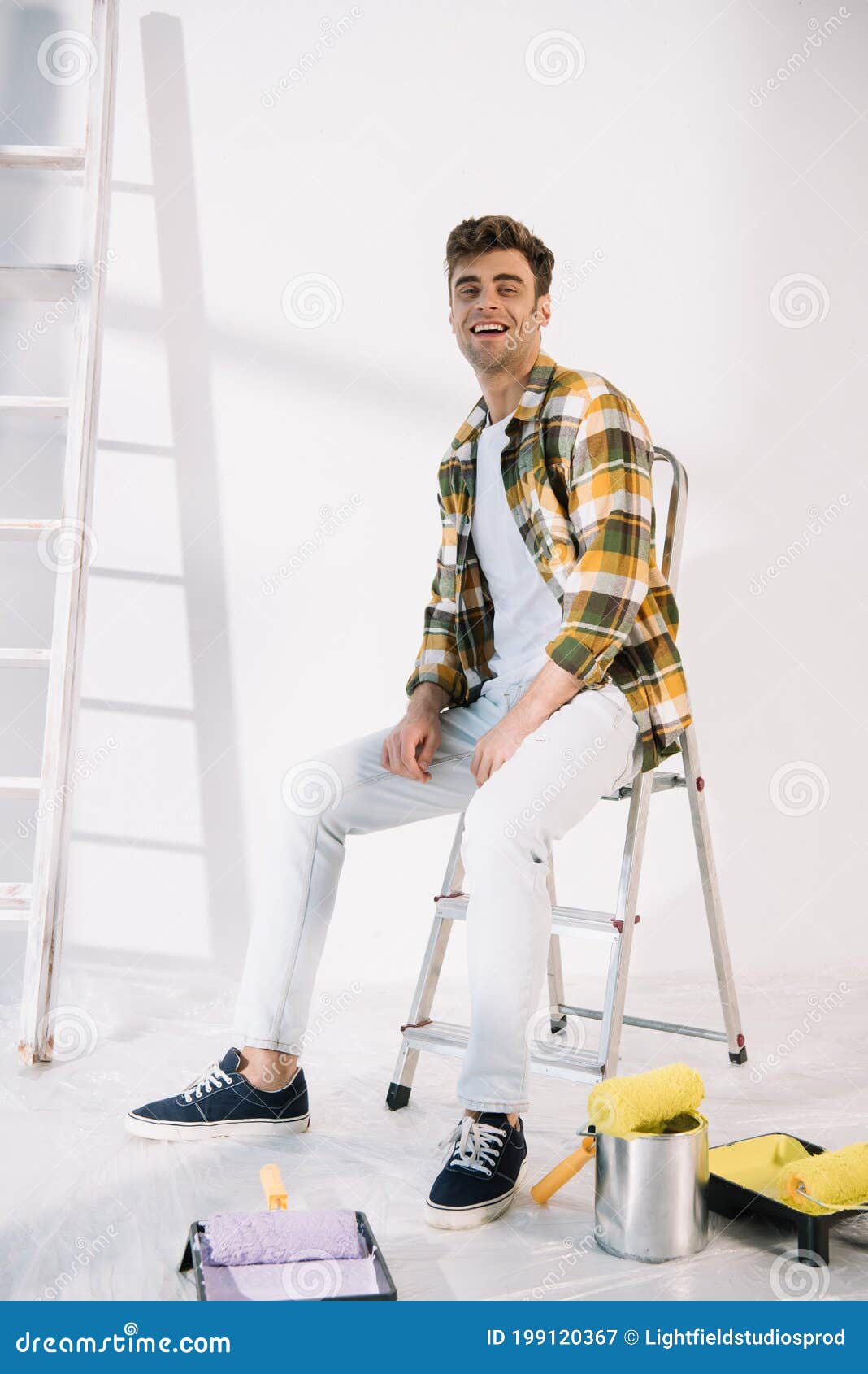 Young Man Smiling while Sitting on Ladder and Looking at Camera Stock ...