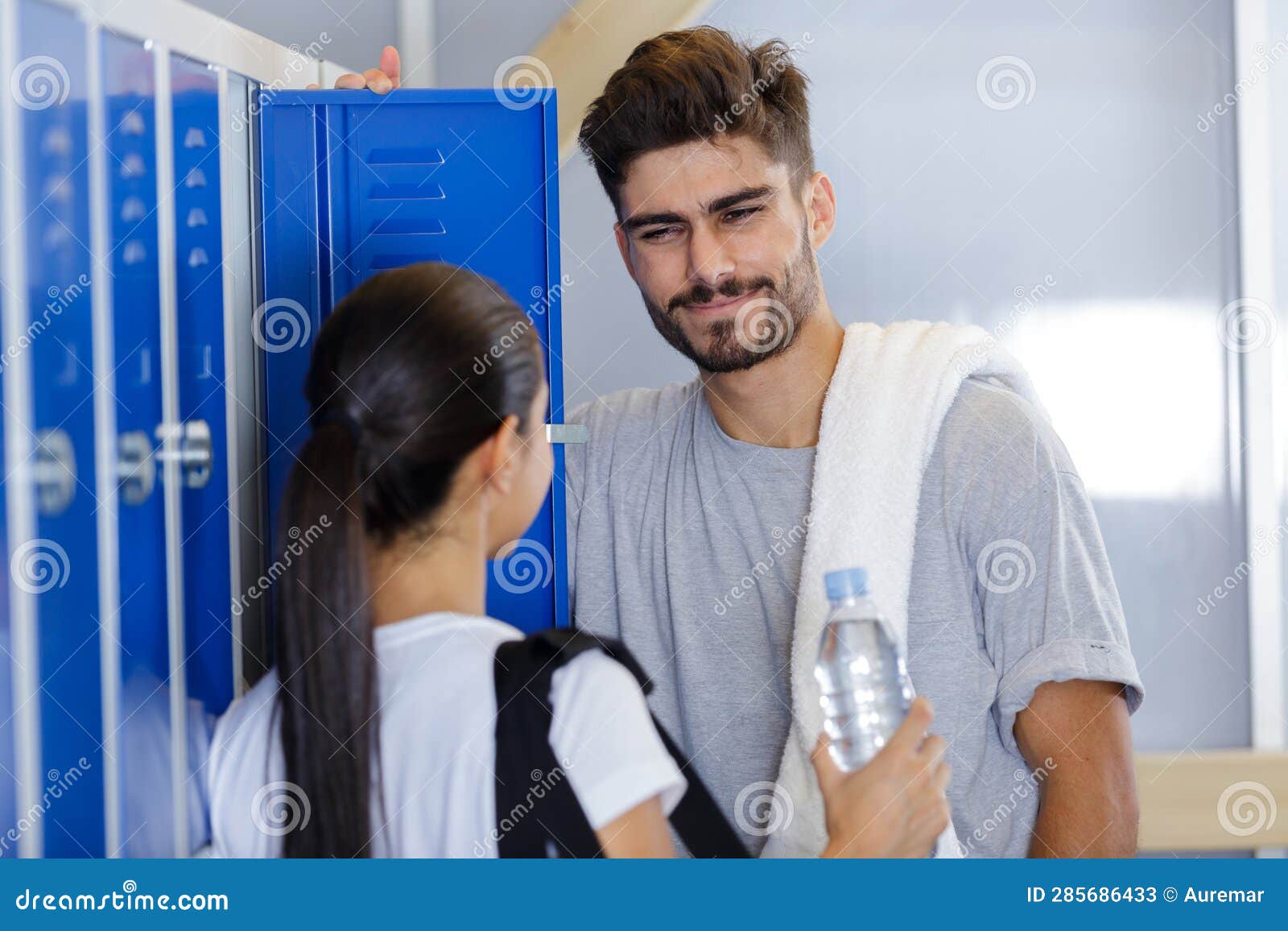 Young Man Smiling at Woman in Locker Room Stock Image - Image of bench ...