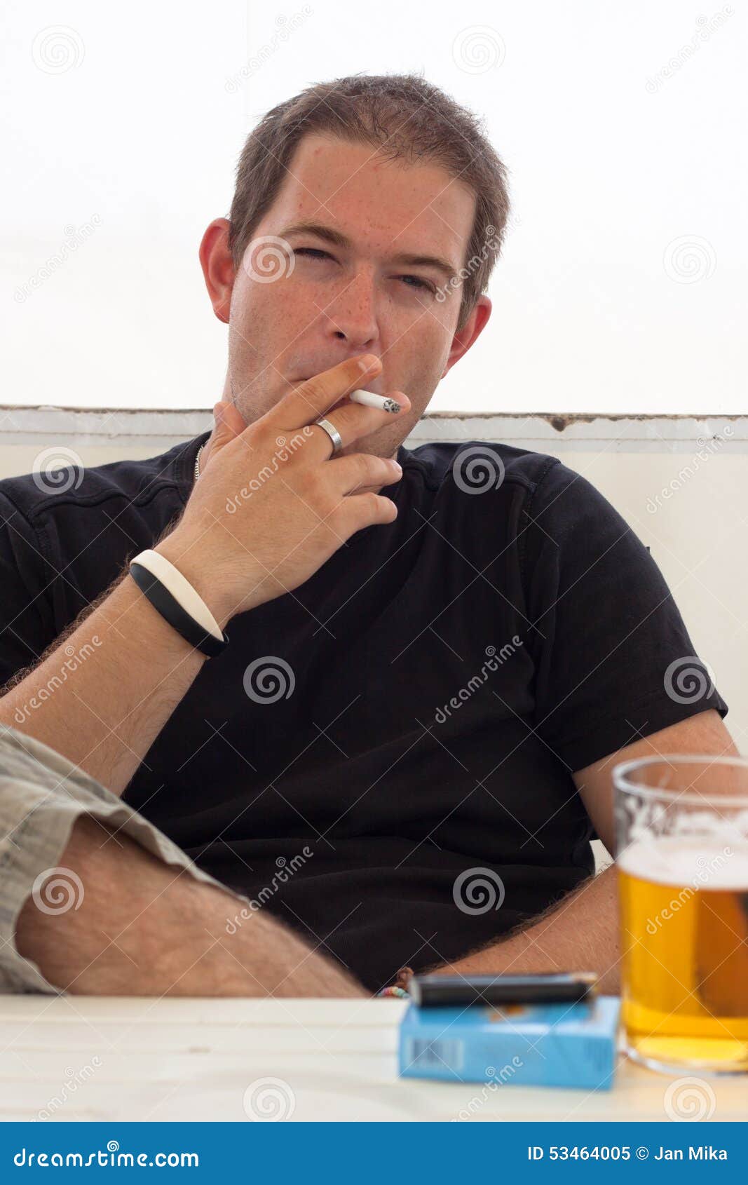 Young Man Smoking Cigarette Stock Image - Image of indoors, holding ...