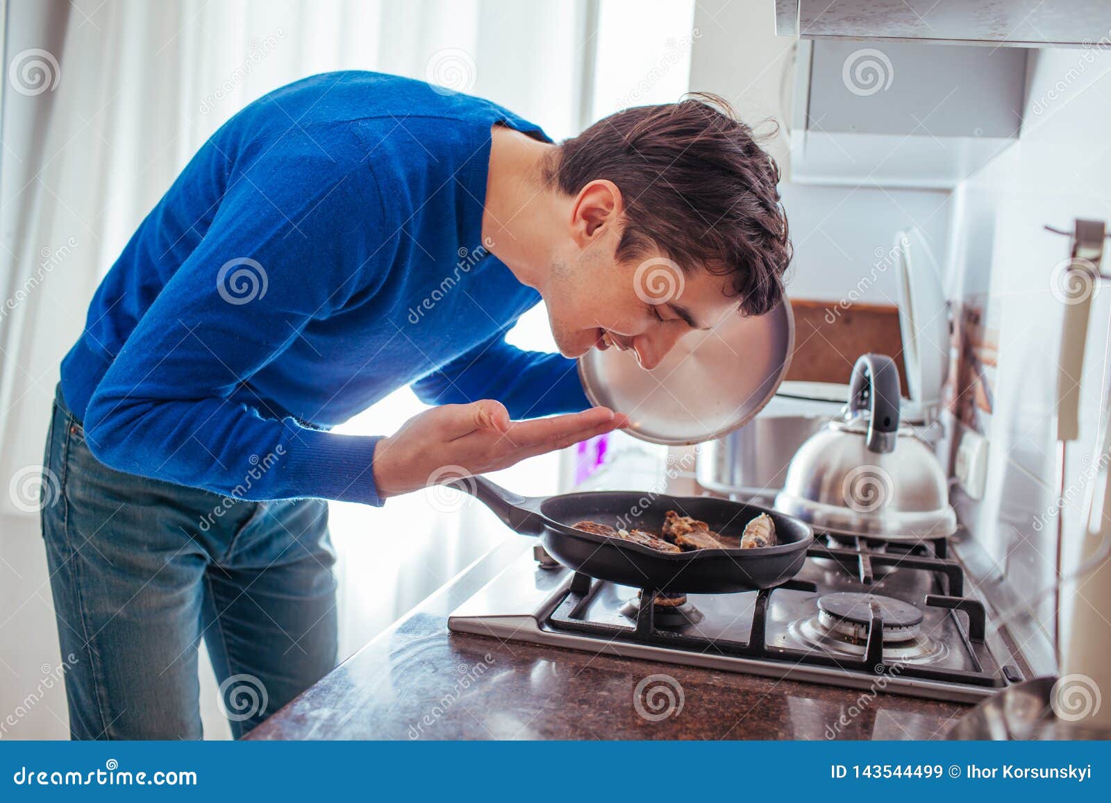 Young Man Sniffing Food from the Pan on Kitchen Stock Image - Image of ...