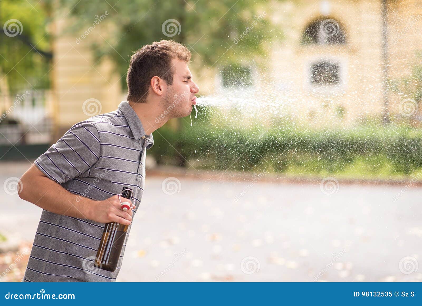 Young man spit out alcohol stock image. Image of park - 98132535