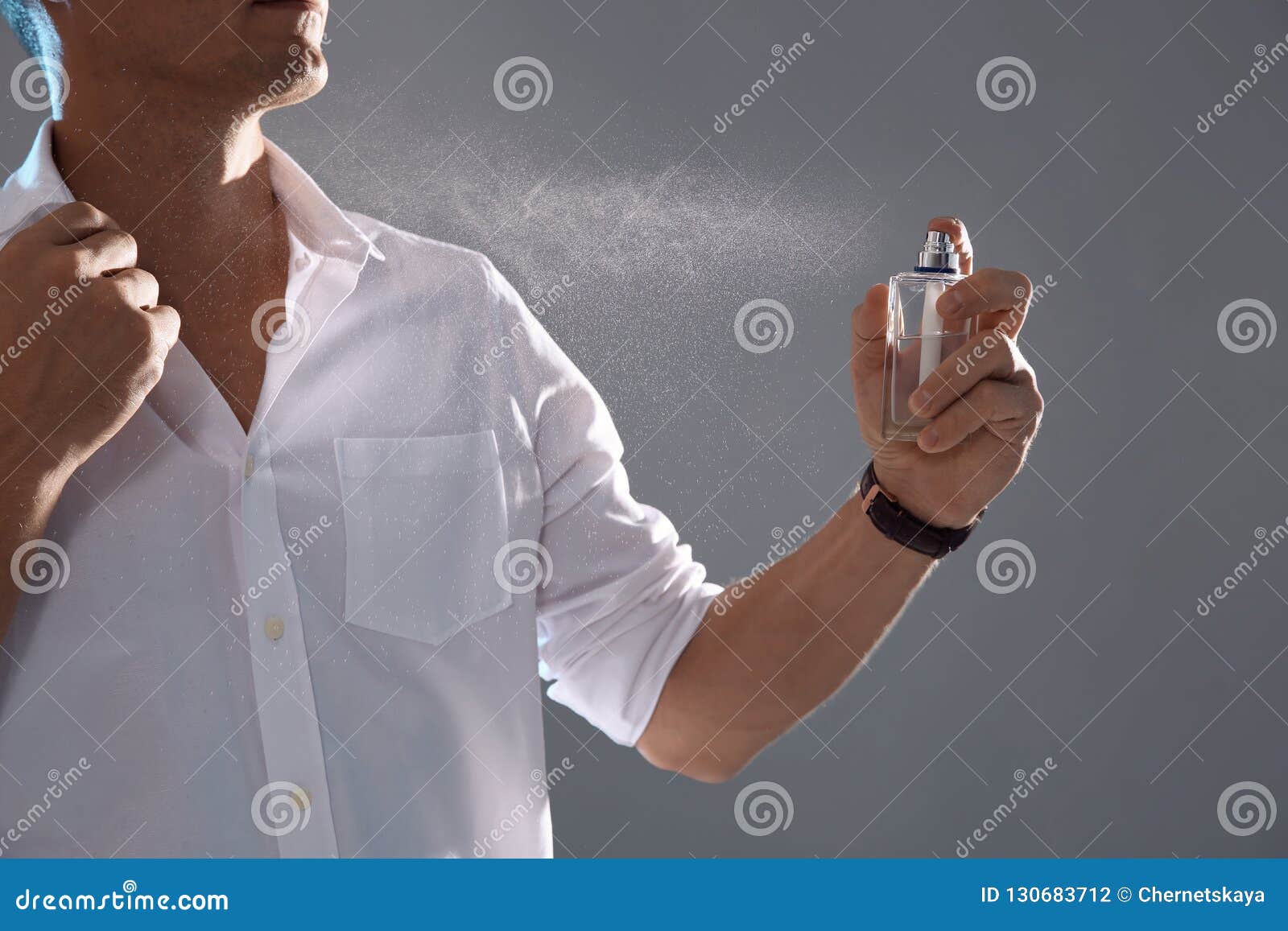 Young man spraying perfume stock photo. Image of applying - 130683712