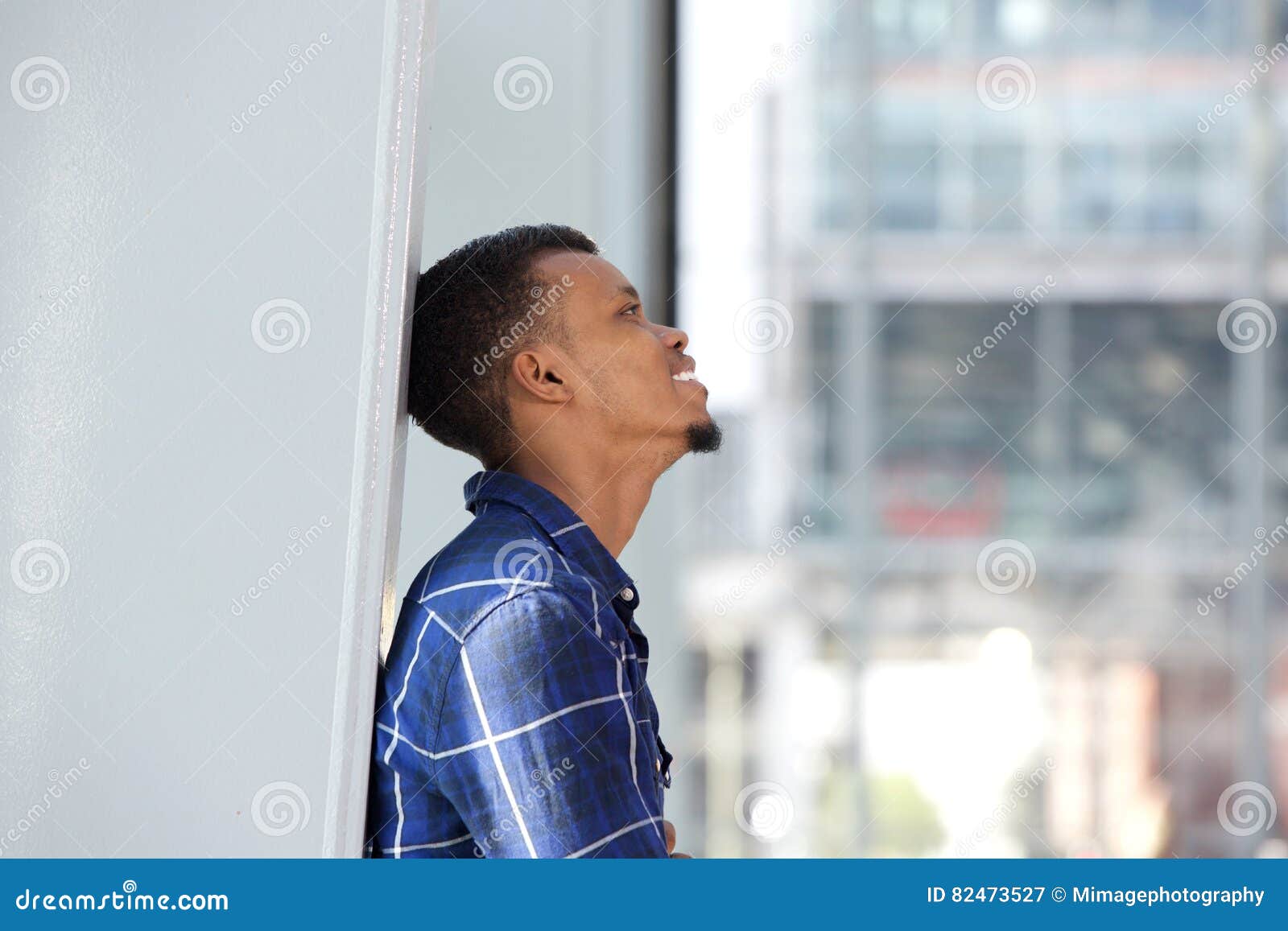 Young Man Standing Against Wall Smiling Stock Image - Image of ...