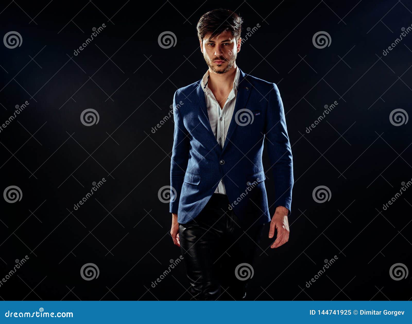 Young Man Standing and Looking Forward. Dark Background Stock Image ...