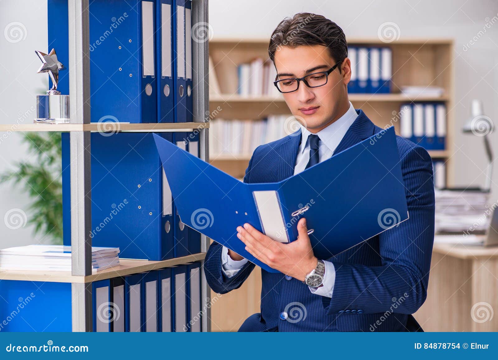 The Young Man Standing Next To the Shelf with Folders Stock Photo ...