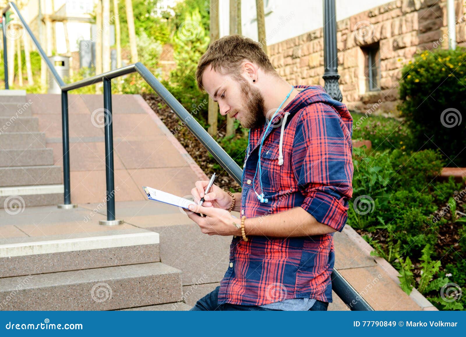 Young Man Standing by Stairs with Clipboard and Writing Stock Image ...