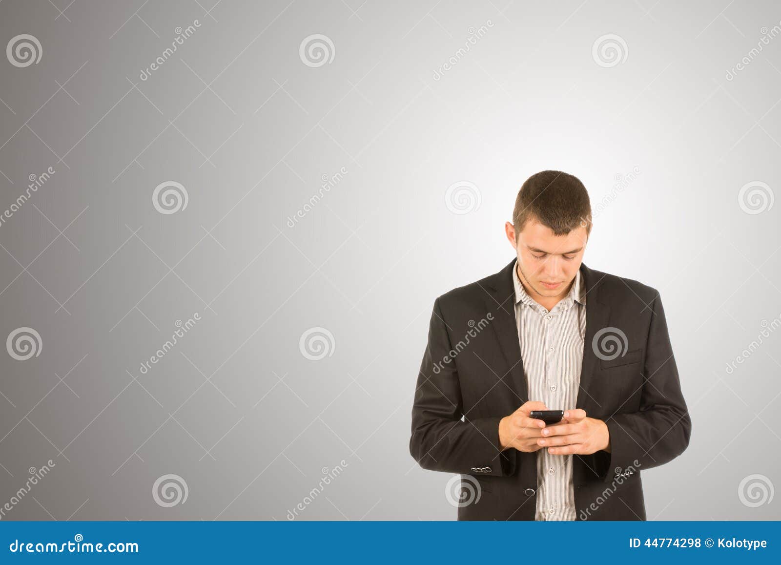 Young Man Standing Texting on His Mobile Phone Stock Photo - Image of ...