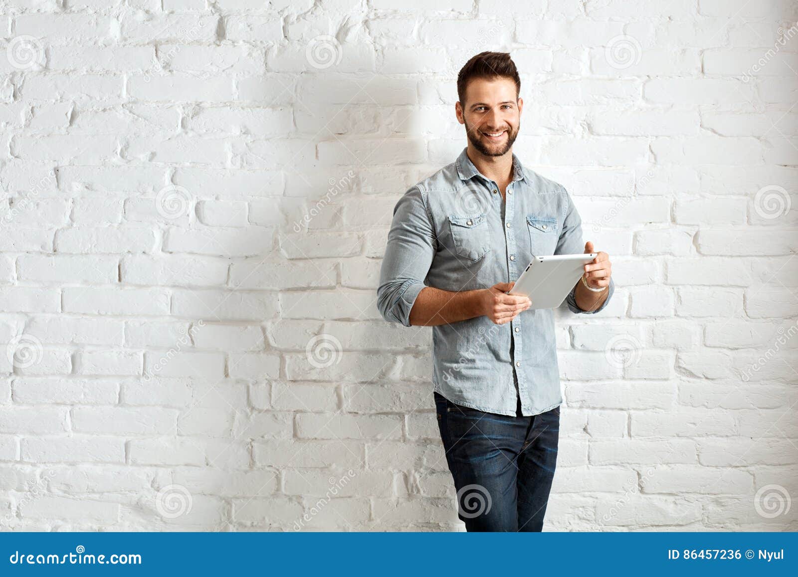 Young Man Standing at Wall Using Tablet Stock Photo - Image of handheld ...