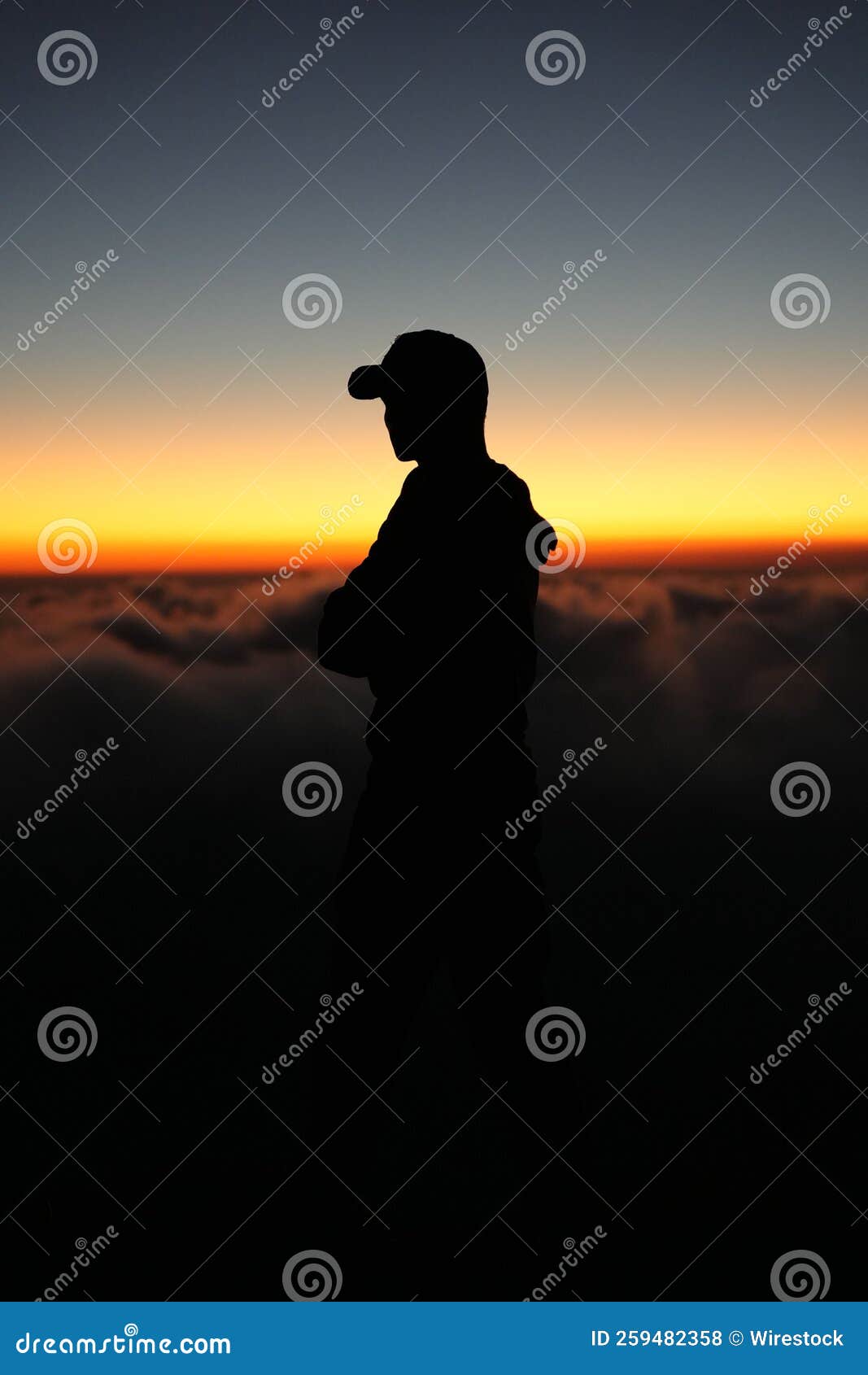A Young Man Staring into the Sunset on the Horizon Over the Clouds ...