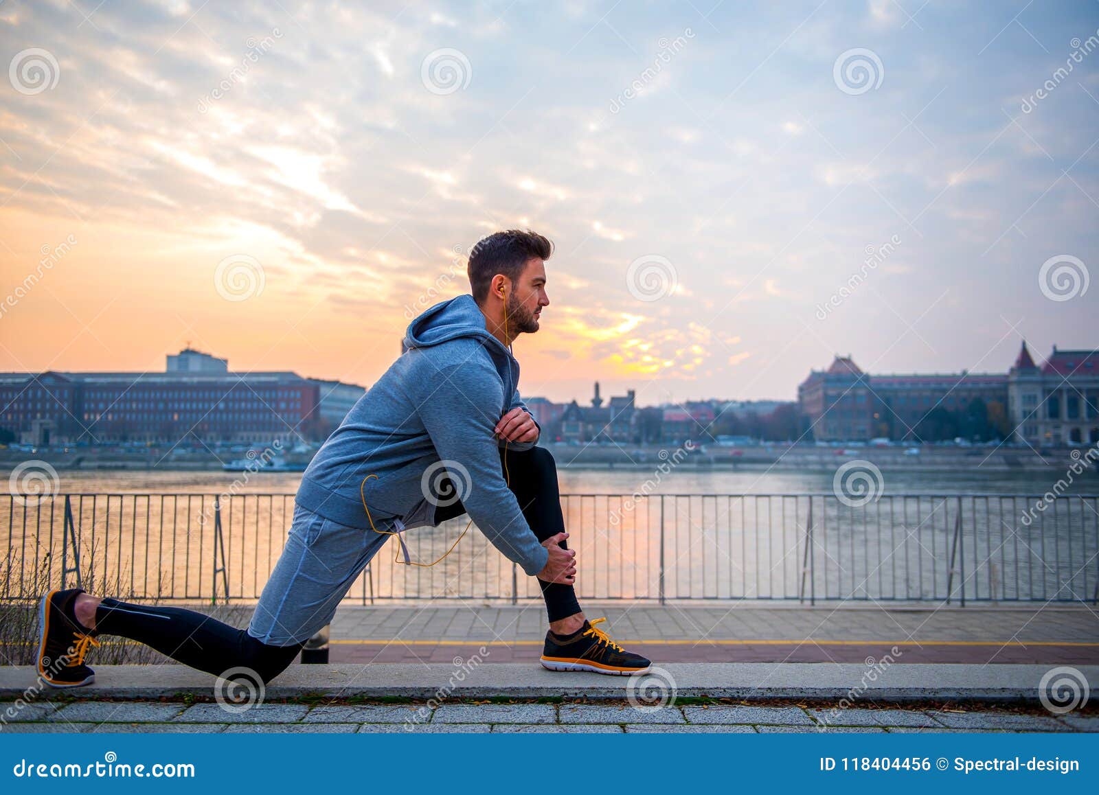 Young man stretching stock photo. Image of clouds, city - 118404456