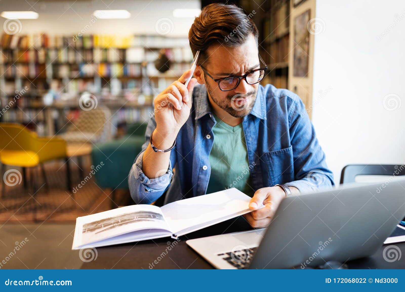 Young Man Student with Laptop Studying in the University Library Stock ...