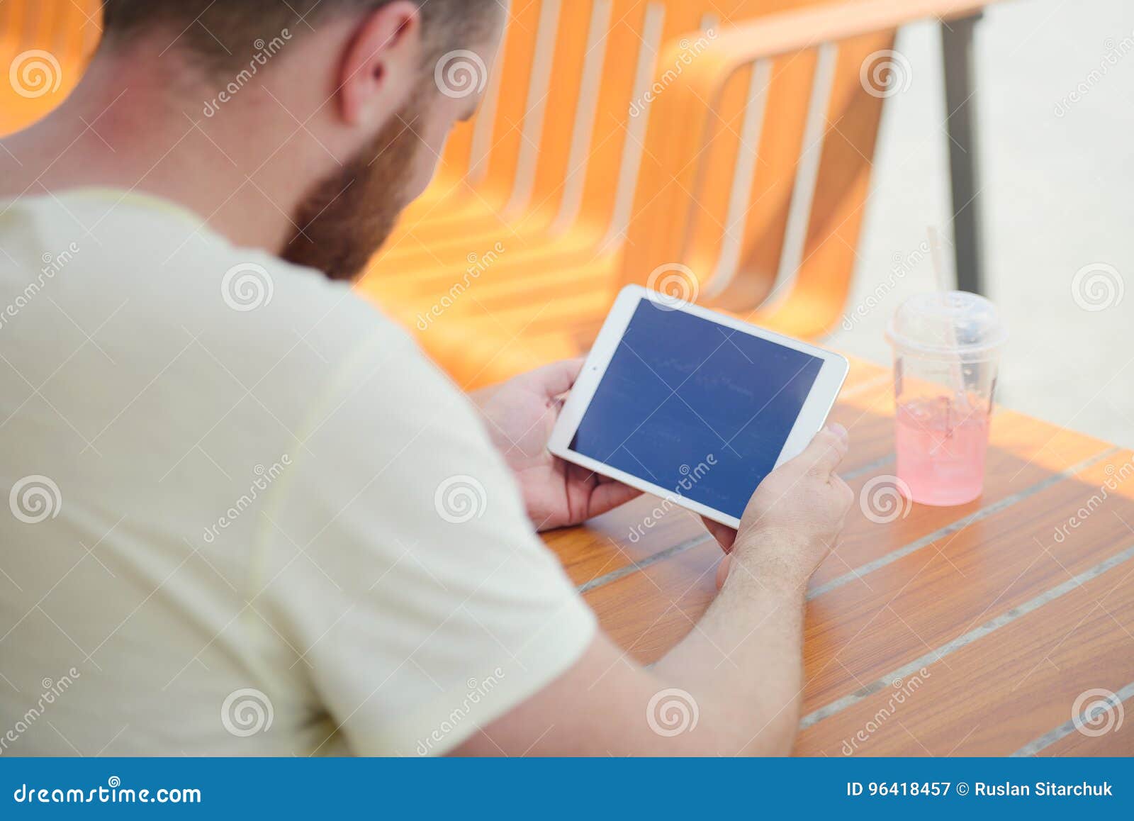 Young Man Student Using a Tablet Computer in a Cafe with a Cool Drink in the City. Stock Image ...