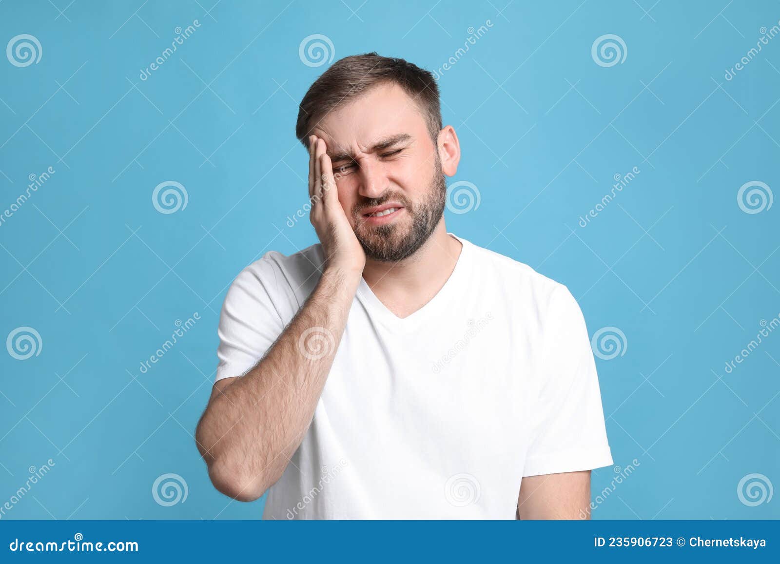 Young Man Suffering from Headache on Light Blue Background Stock Image ...