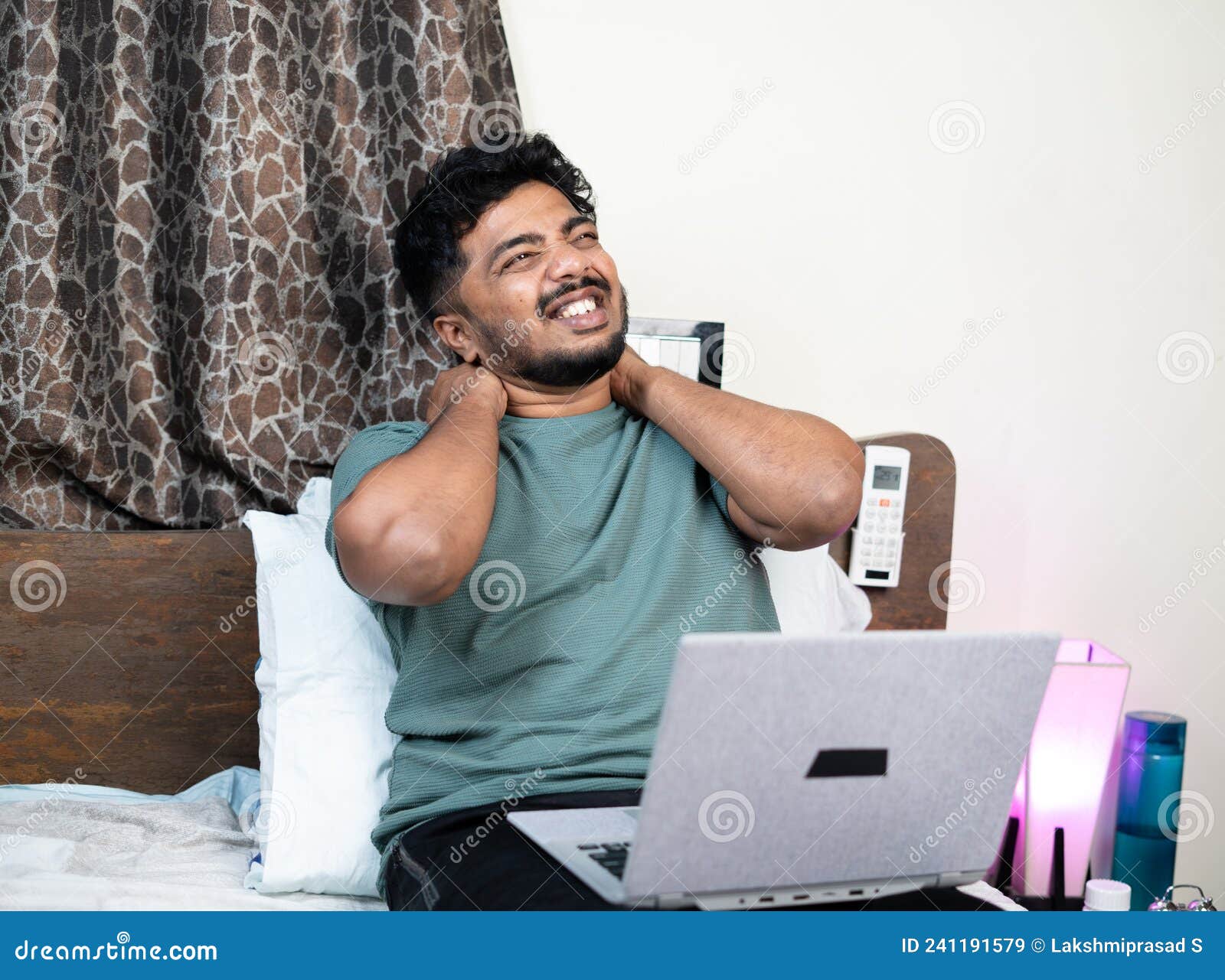 Young Man Suffering from Neck and Back Pain while Using Laptop on Bed ...