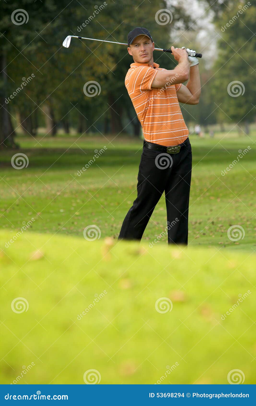 Young Man Swinging Golf Club Stock Photo - Image of front, playing ...