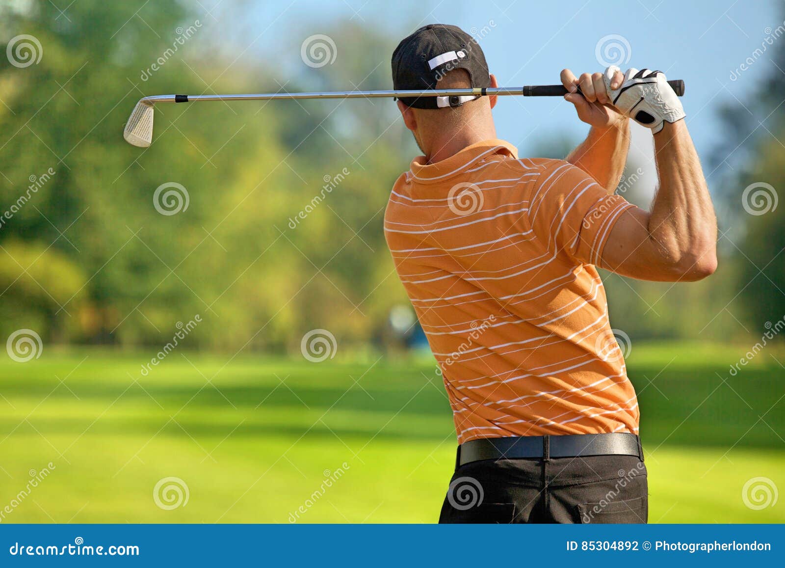 Young Man Swinging Golf Club, Rear View Stock Photo - Image of ...