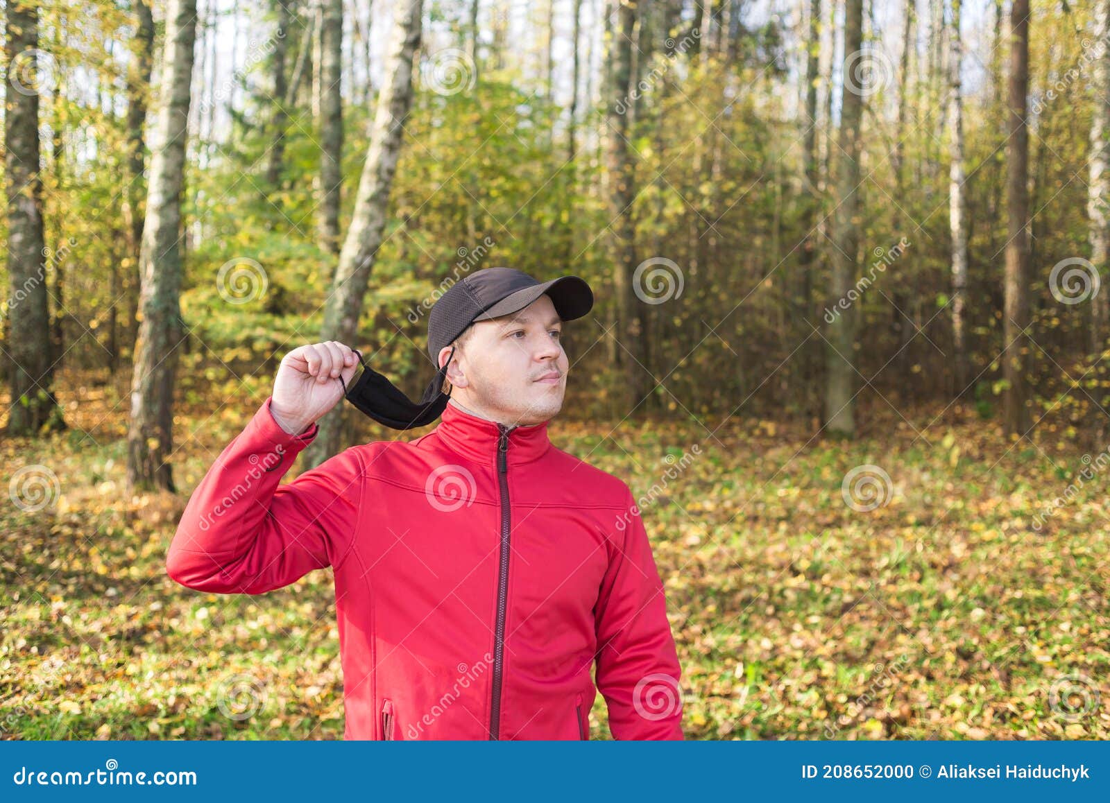 Young Man Takes Off His Mask Outdoors. Portrait of a Young Man Takes ...