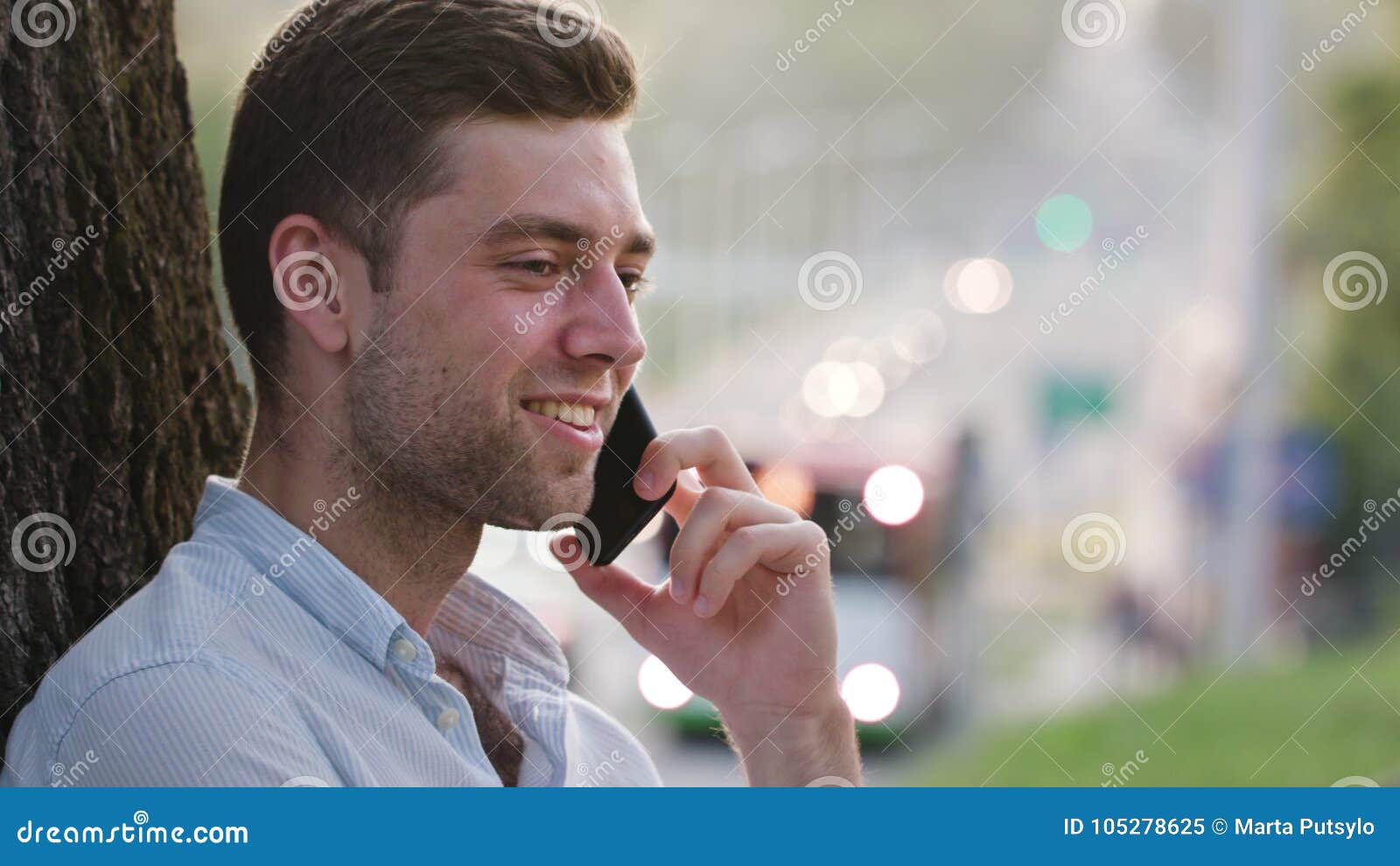 A Young Man Talking on the Phone Under a Tree Stock Image - Image of ...