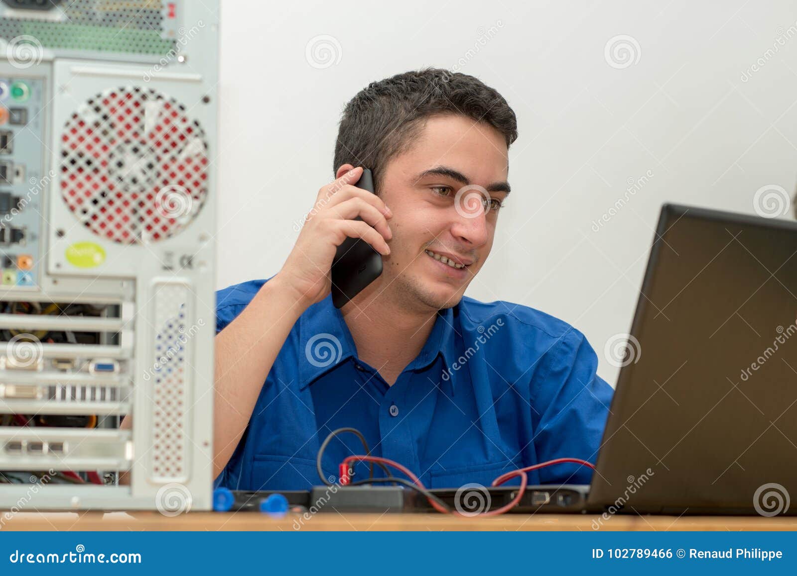 Young Man Technician Working on Broken Computer and Call the Customer ...